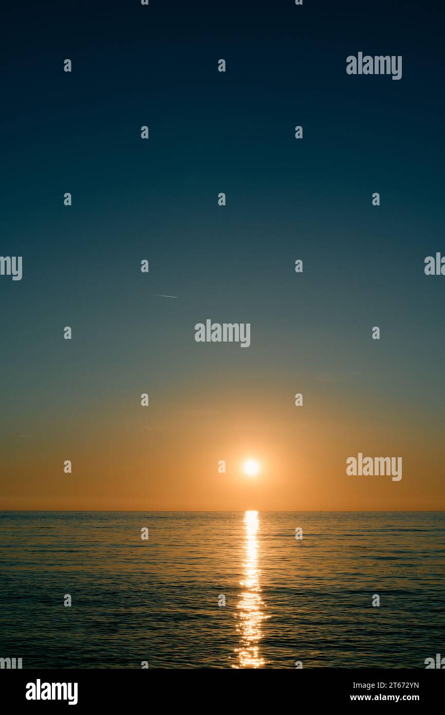 Sparkling path from the rays of the orange sunset sun on the sea Stock ...