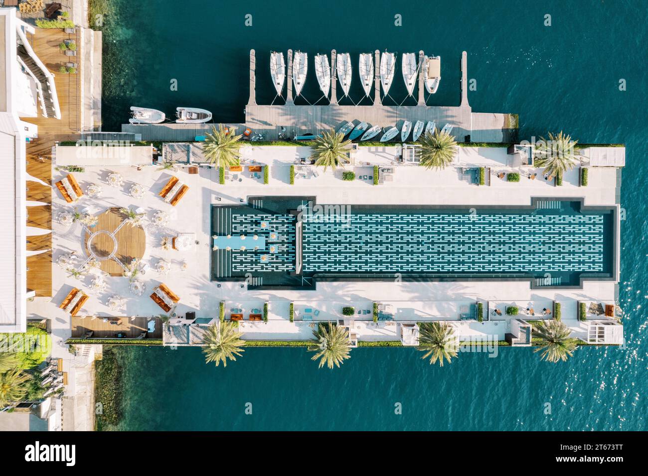 Party tables sit near a circular stage by the long pool on the pier ...