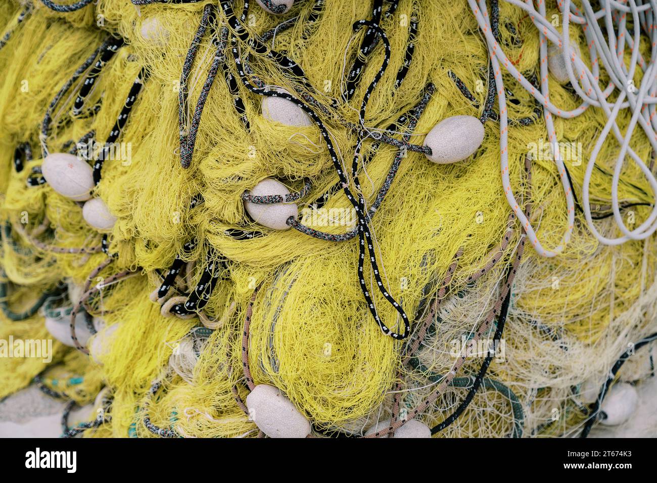Folded yellow fishing net with white floats. Top view Stock Photo - Alamy