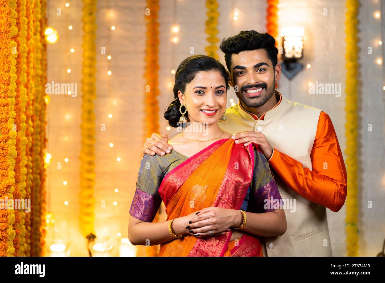 Happy smiling young indian couple in traditional ethnic wear by looking ...