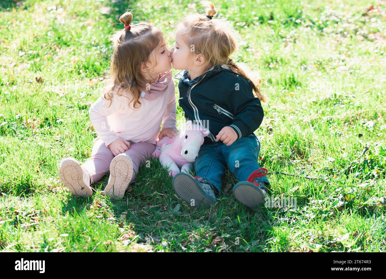 Cute kids love. Little girl kissing little boy outdoors in park ...