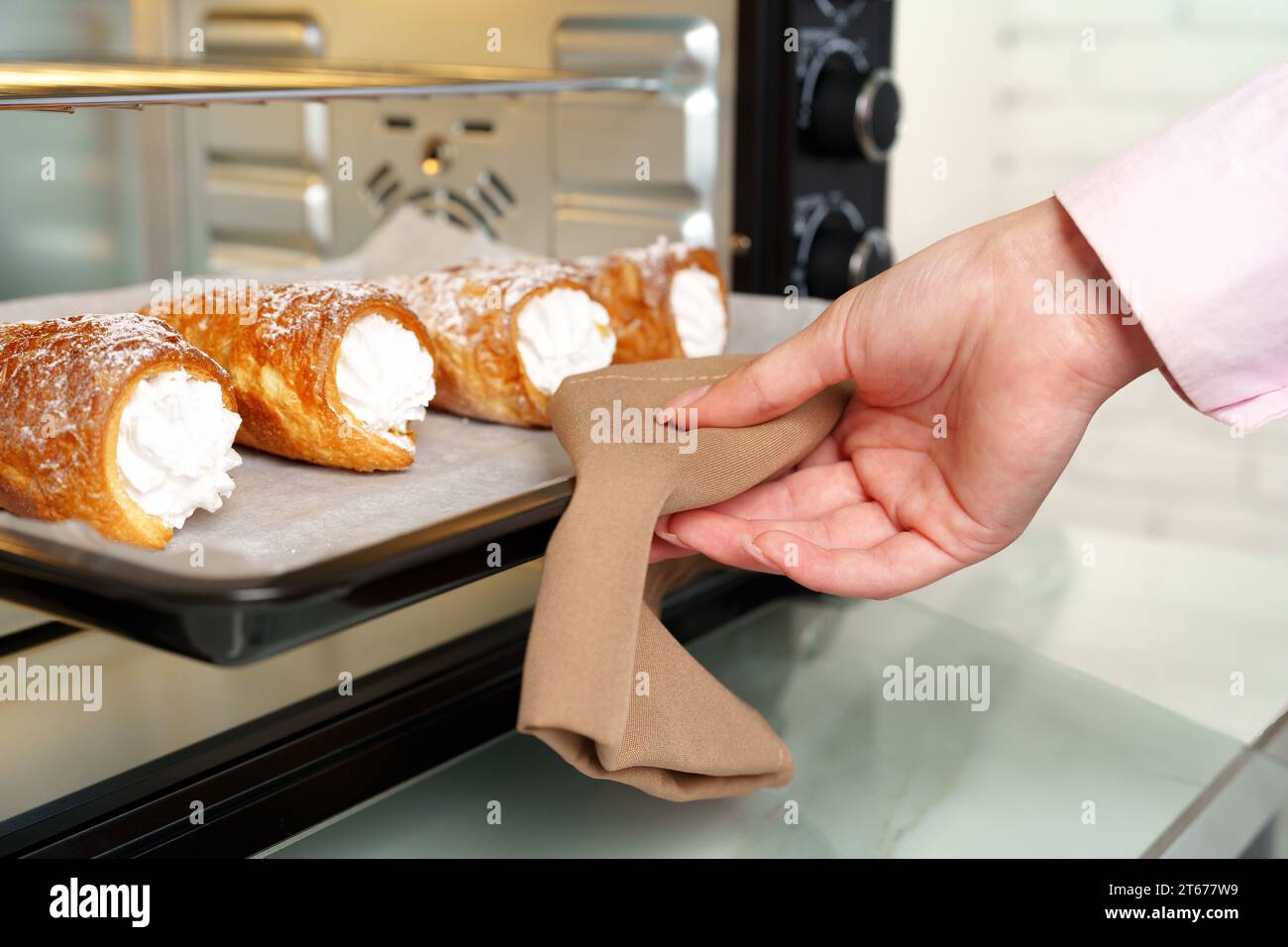 Woman's hands taking fresh bakery out of mini oven Stock Photo - Alamy