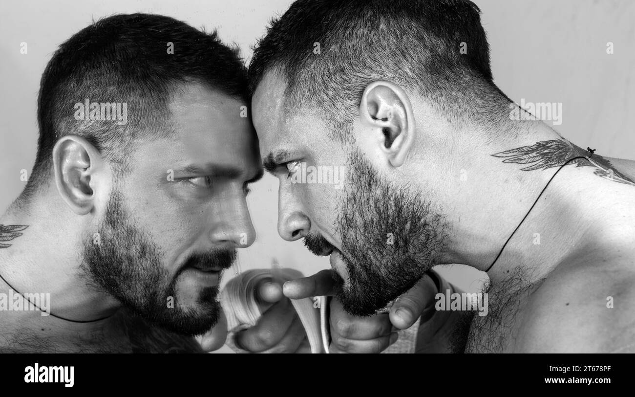 A mirror where a man watching himself. Man and mirror. Bearded hispanic ...