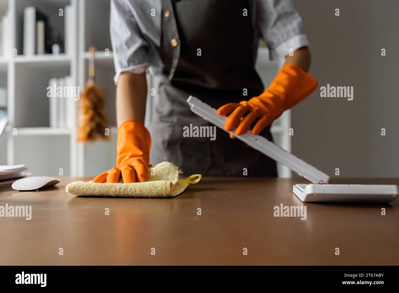 Woman maid cleaning and wiping the table with microfiber cloth in ...