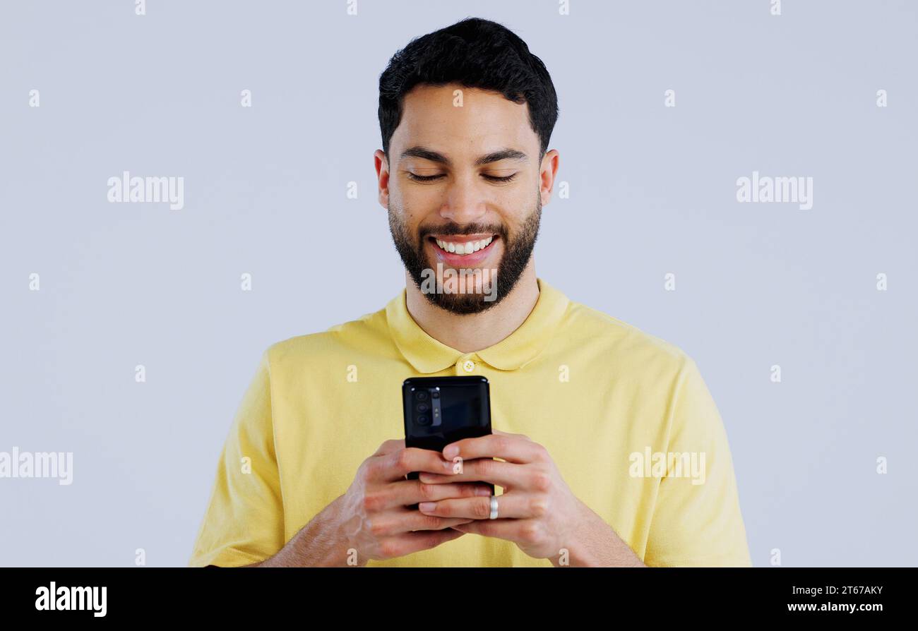 Man, smile and typing with phone in studio, scroll social media and ...