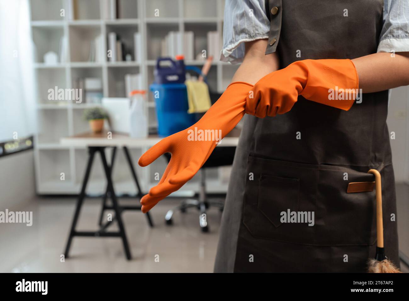 Female housekeeper smile and wearing glove, preparing to clean office ...