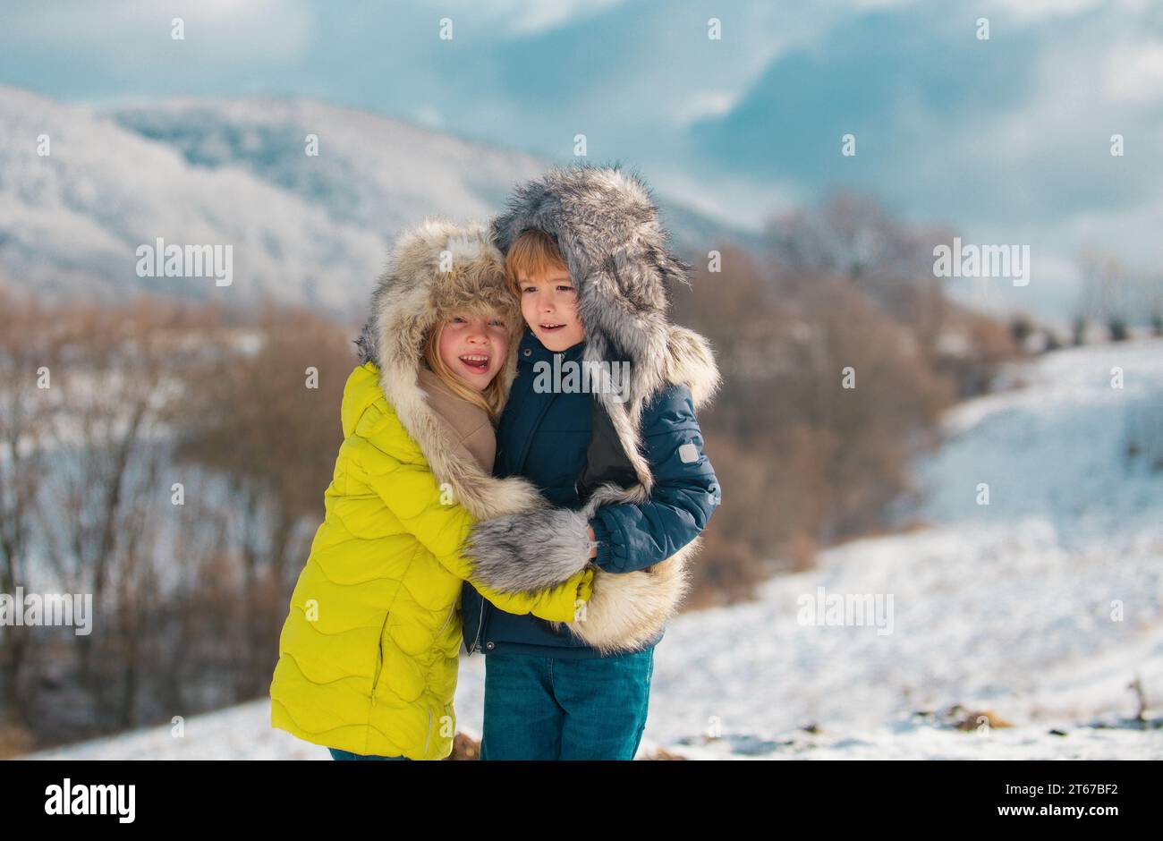 Funny little children hugging in winter outdoor. Smiling kids friends ...