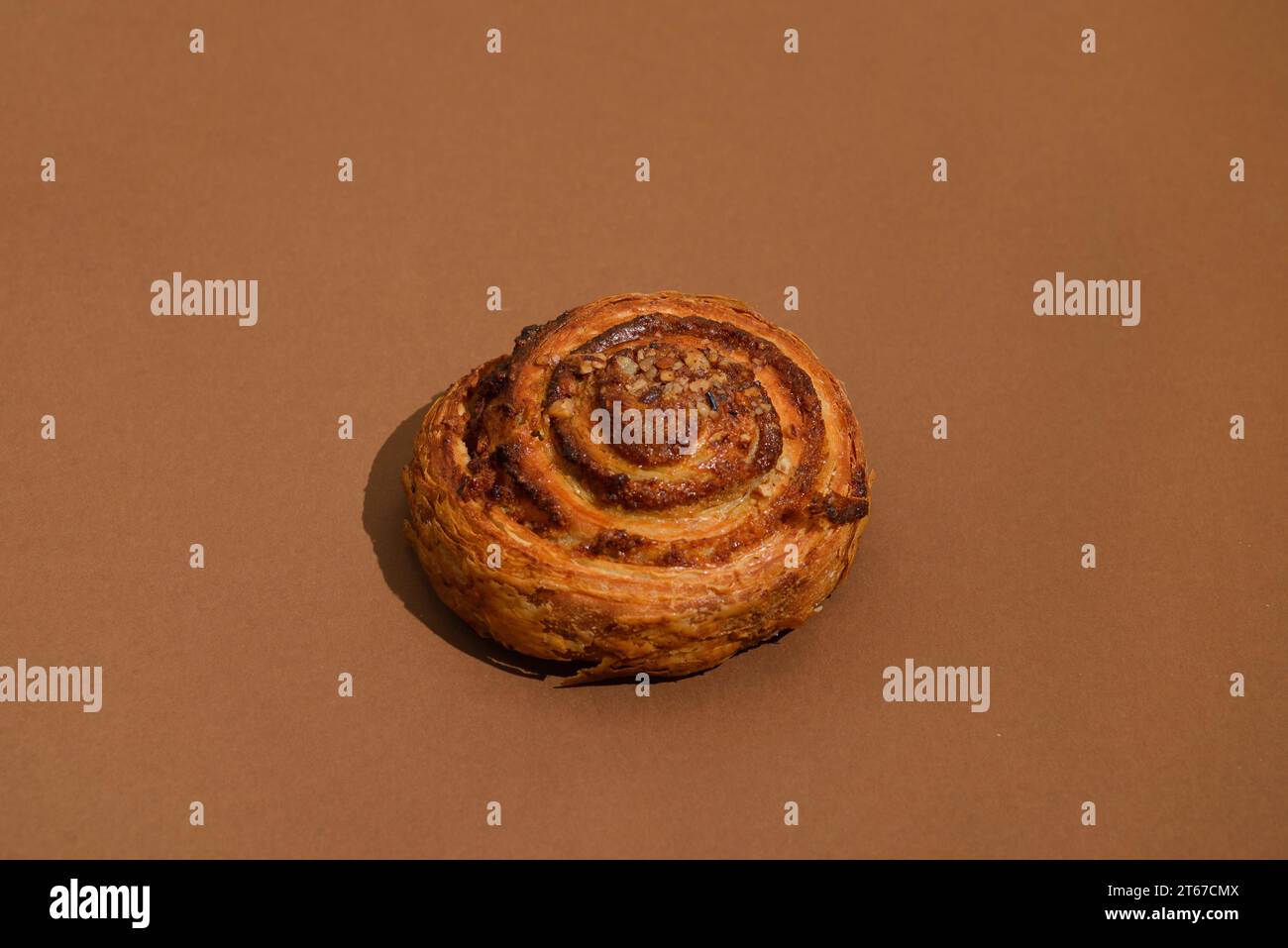 Cinnabon with cinnamon on a brown background. High quality photo Stock ...