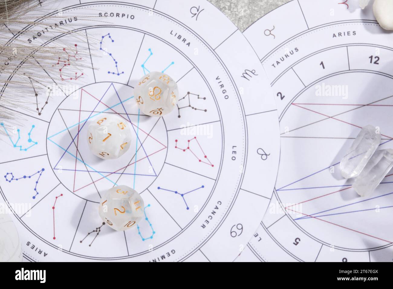 Zodiac wheel, natal chart, astrology dices and stones on grey table ...