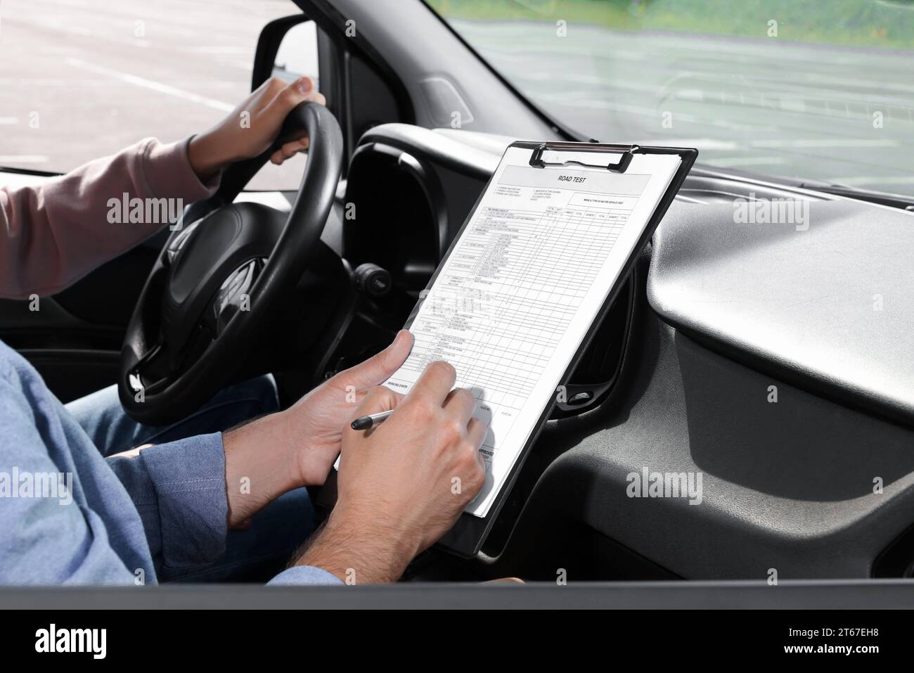 Driving school. Student passing driving test with examiner in car at ...