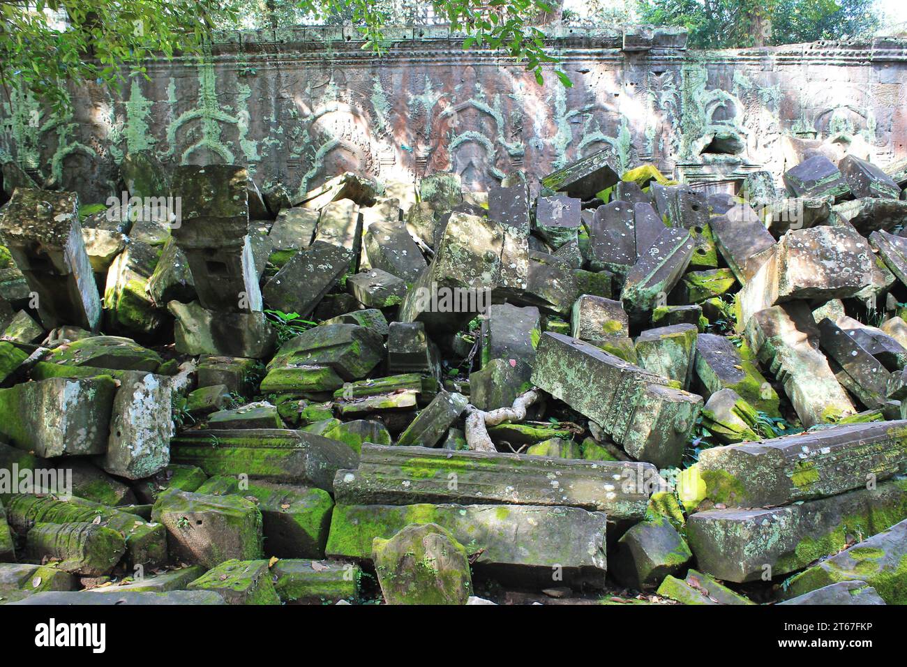 Jumbled pile of moss covered stones among the ruins at Angkor ...