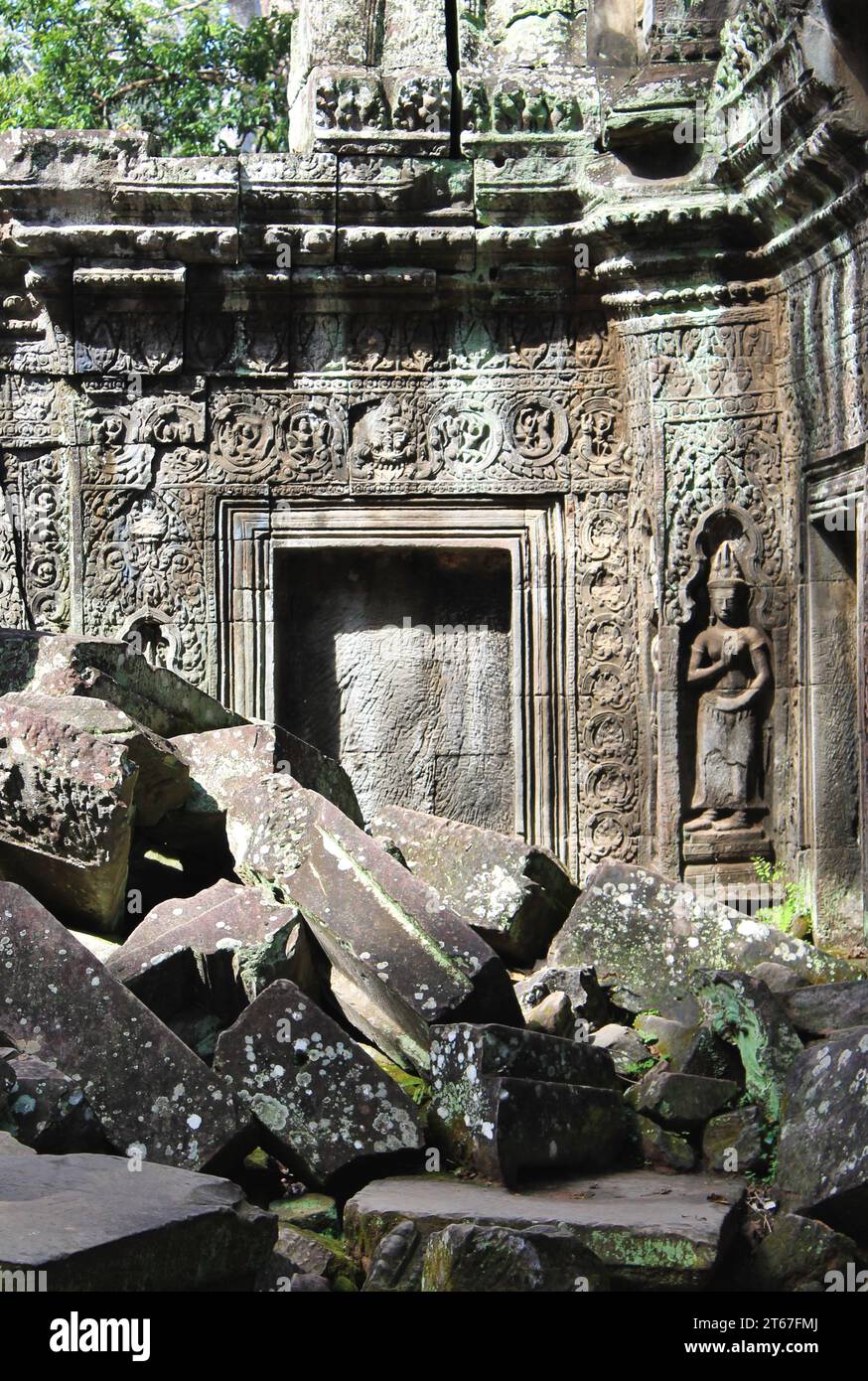 Carved stone reliefs cover the walls of this temple remnant at Angkor ...