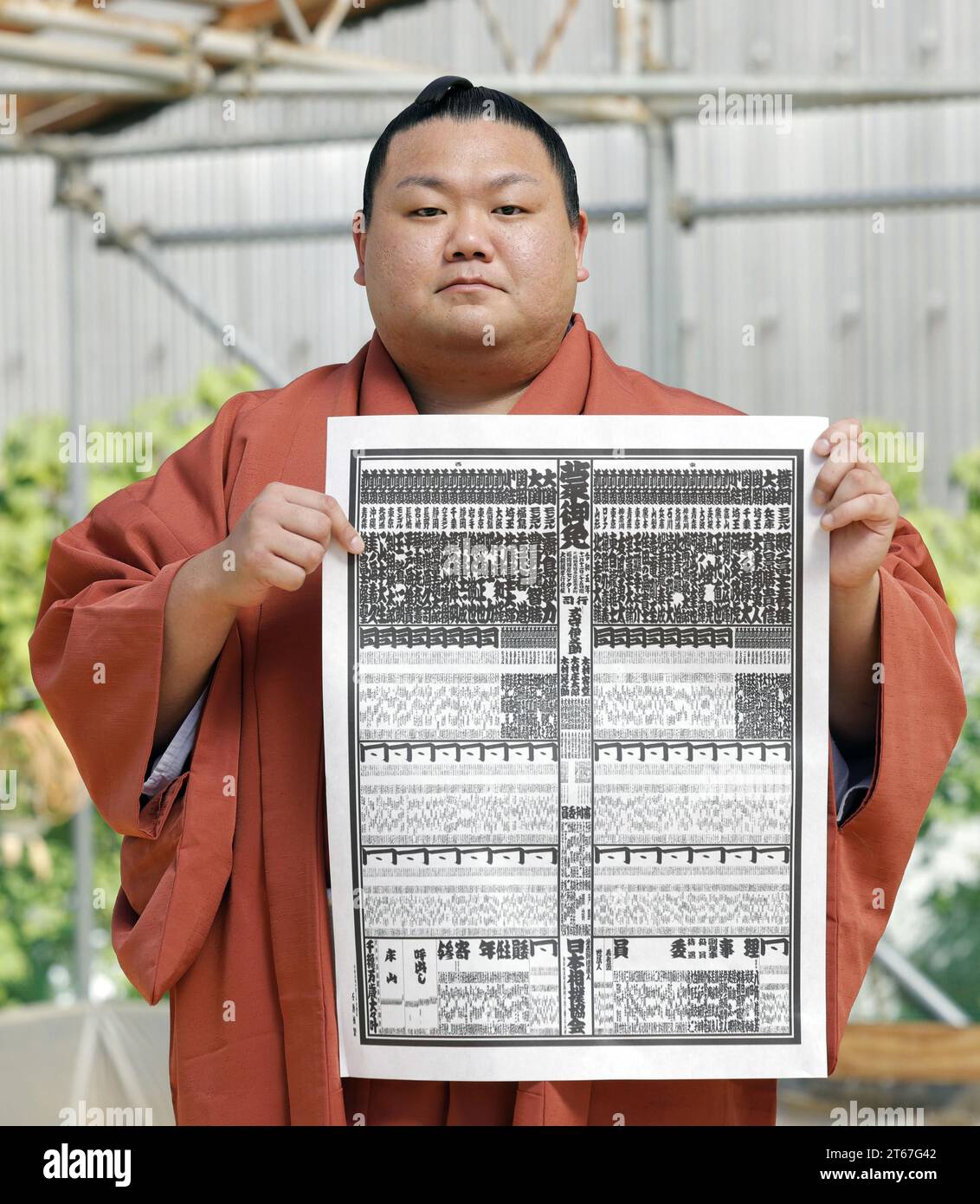 Rank-and-file wrestler Churanoumi holds up the banzuke for the upcoming ...