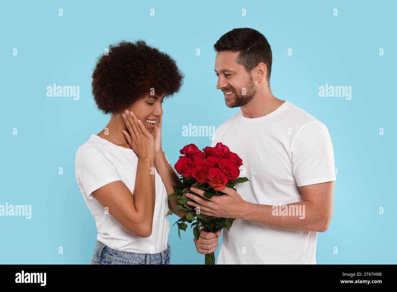 International dating. Handsome man presenting roses to his beloved ...