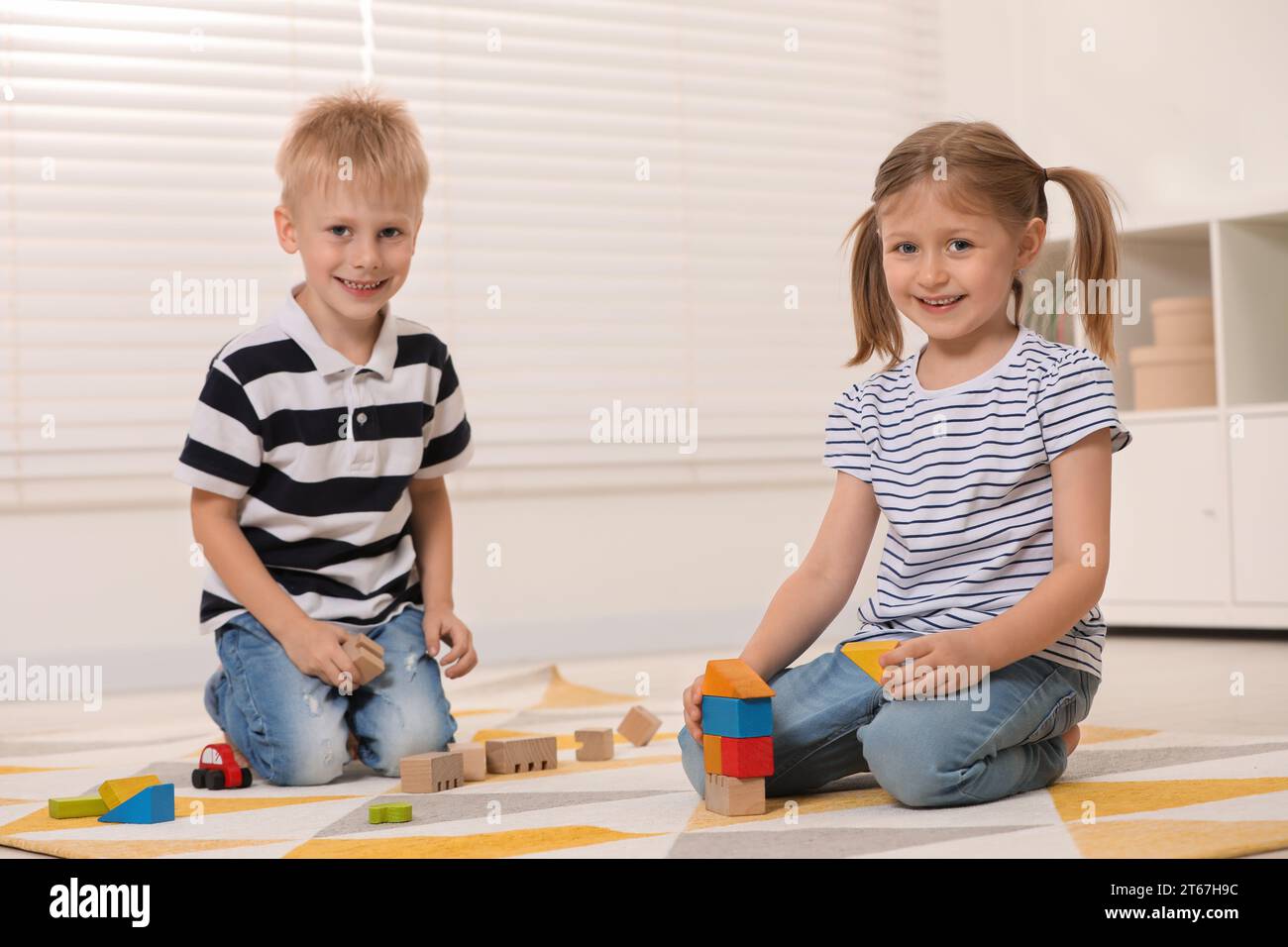 Little children playing with building blocks indoors. Wooden toys Stock ...