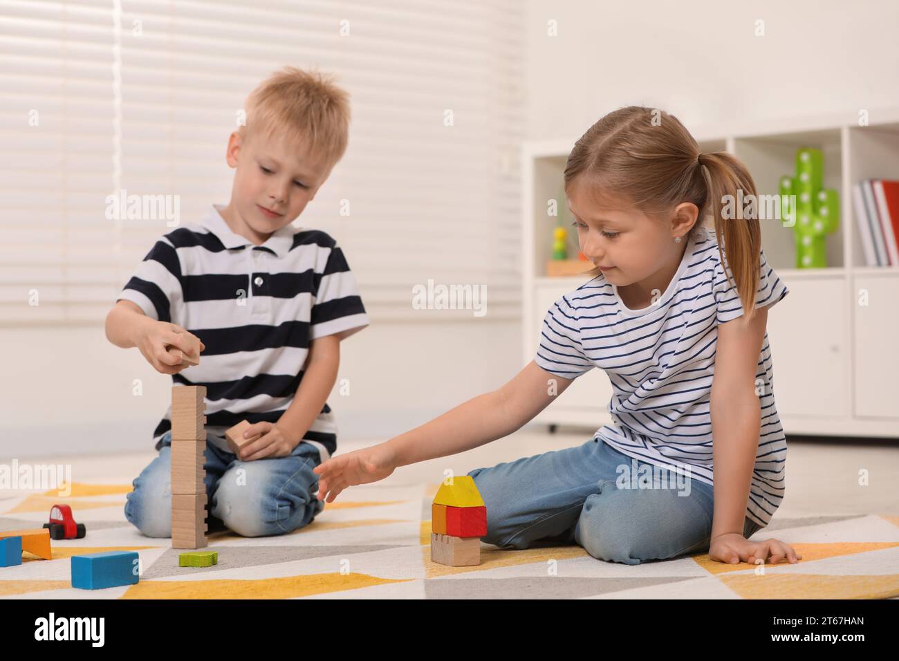 Little children playing with building blocks indoors. Wooden toys Stock ...