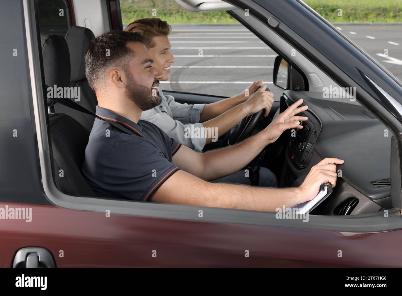 Driving school. Happy student passing driving test with examiner in car ...