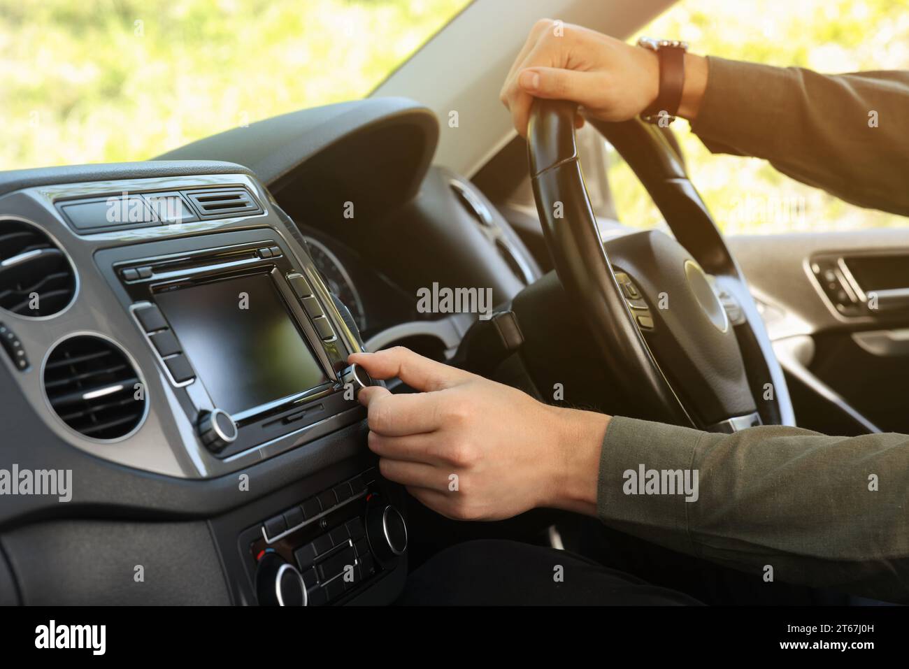 Listening to radio while driving. Man turning volume button on vehicle ...