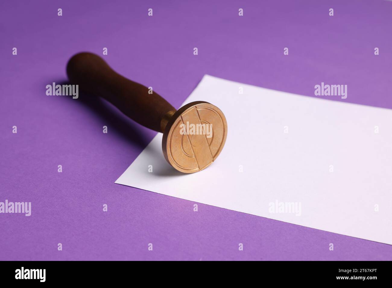 One stamp tool and sheet of paper on purple background, closeup Stock ...