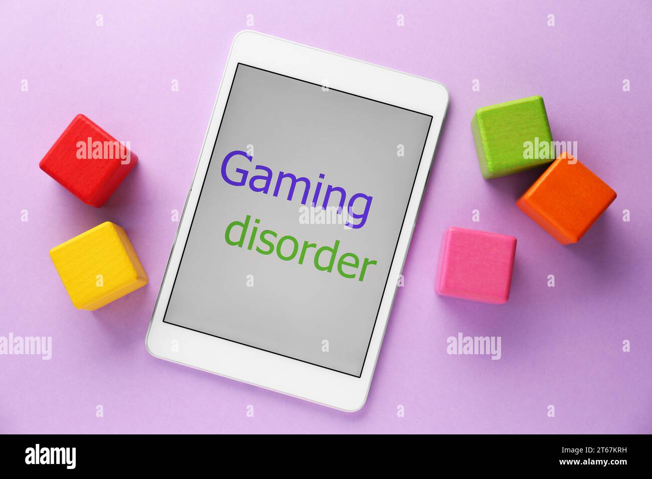Tablet with phrase Gaming Disorder and colorful cubes on violet ...