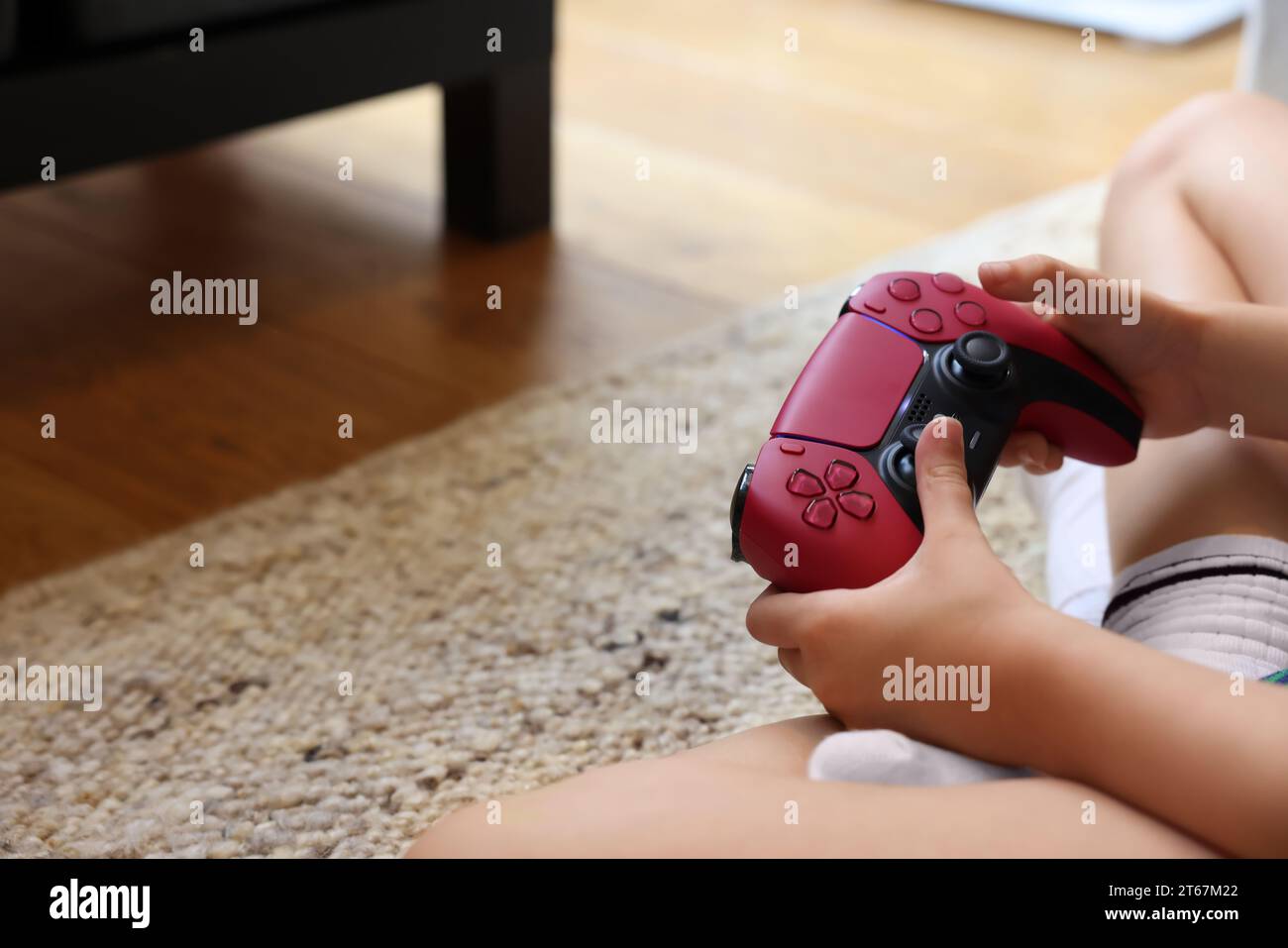Child playing video games with controller indoors, closeup. Space for ...
