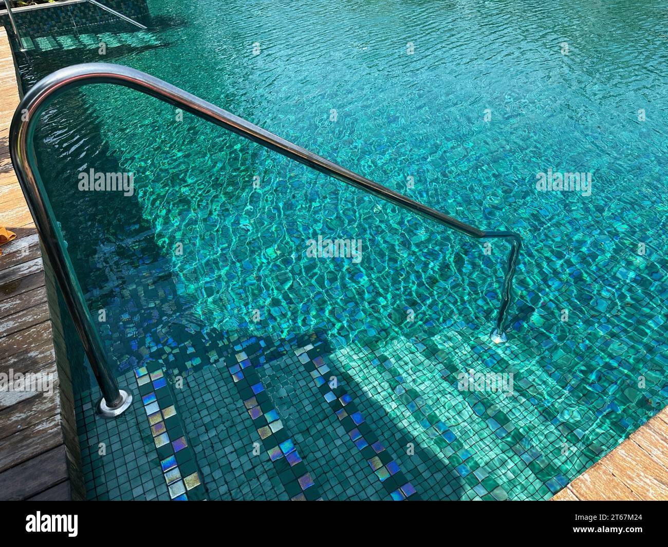 Metal rail and steps in outdoor swimming pool Stock Photo - Alamy