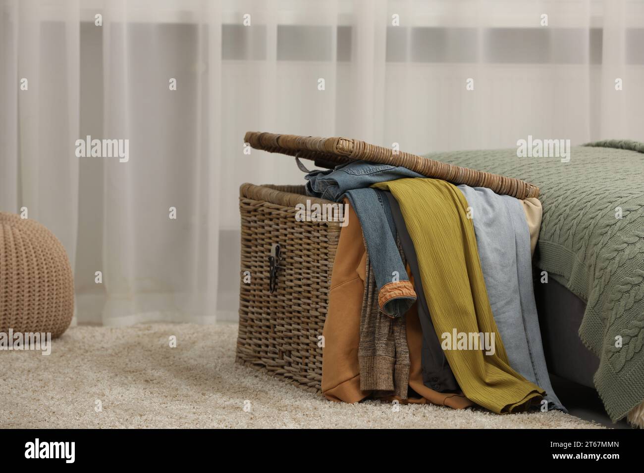 Sorting and organizing. Basket with many different clothes in room ...