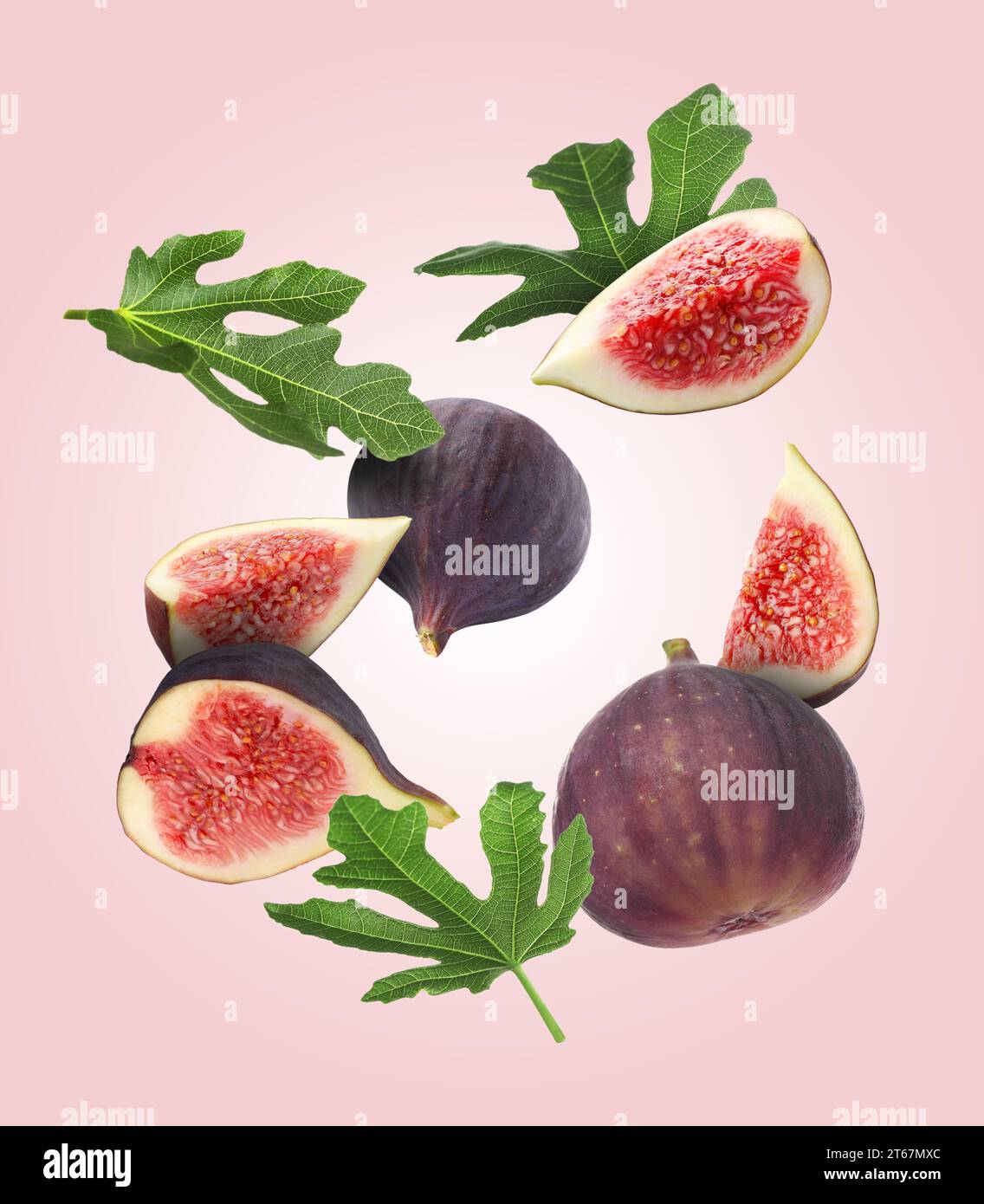 Fresh figs and green leaves falling on pastel pink background Stock ...
