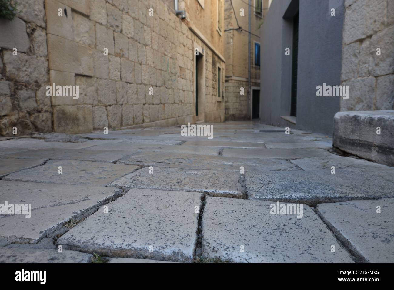 Empty paved alleyway between residential buildings in town Stock Photo ...