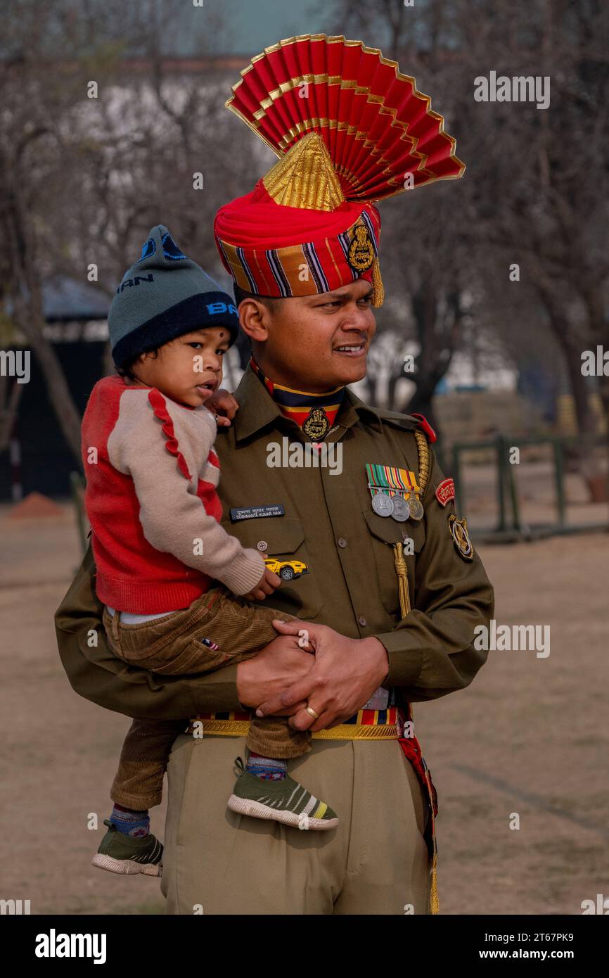 A Indian Border Security Force (BSF) solider holds his son as they ...