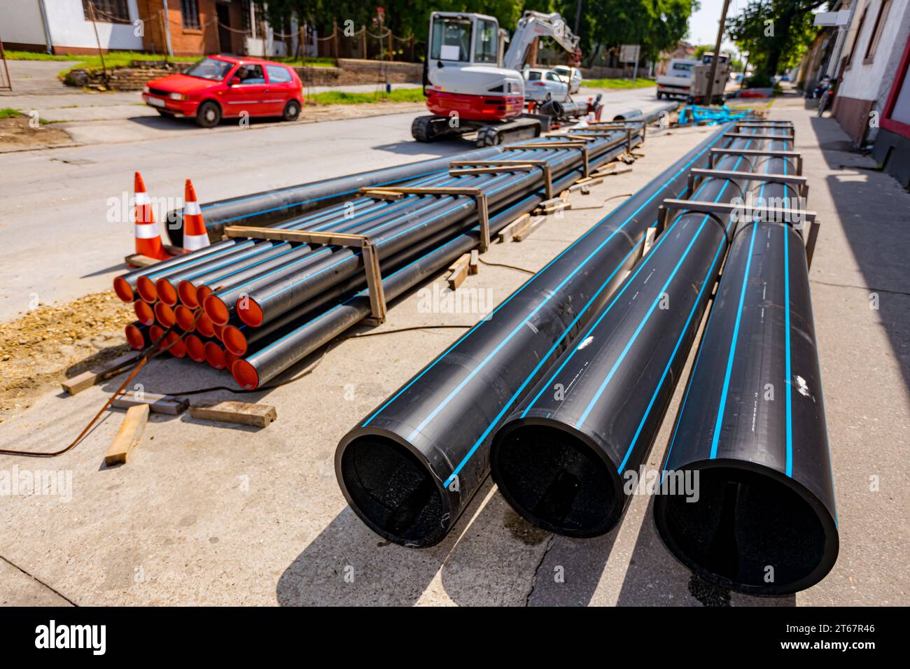 Few new plastic water pipes are stacked on the street, ready to be ...