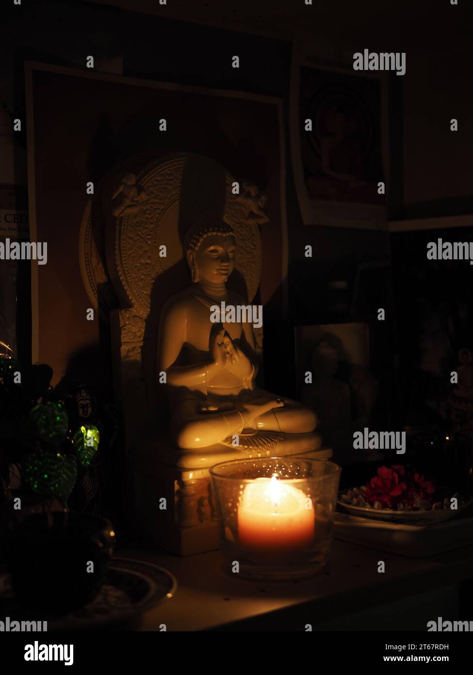 Candle lit Buddha statue with flowers and model Bodhi tree Stock Photo ...