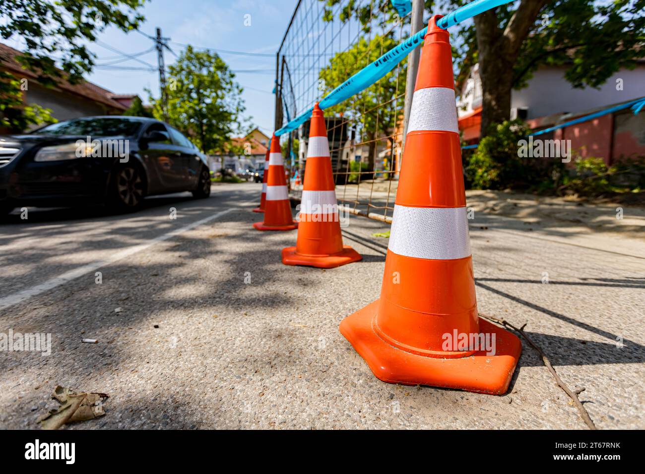 Several orange traffic cones with white fluorescent stripes are on the ...