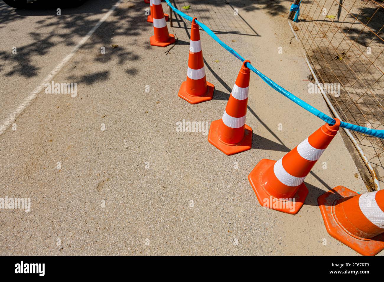 Several orange traffic cones with white fluorescent stripes are on the ...