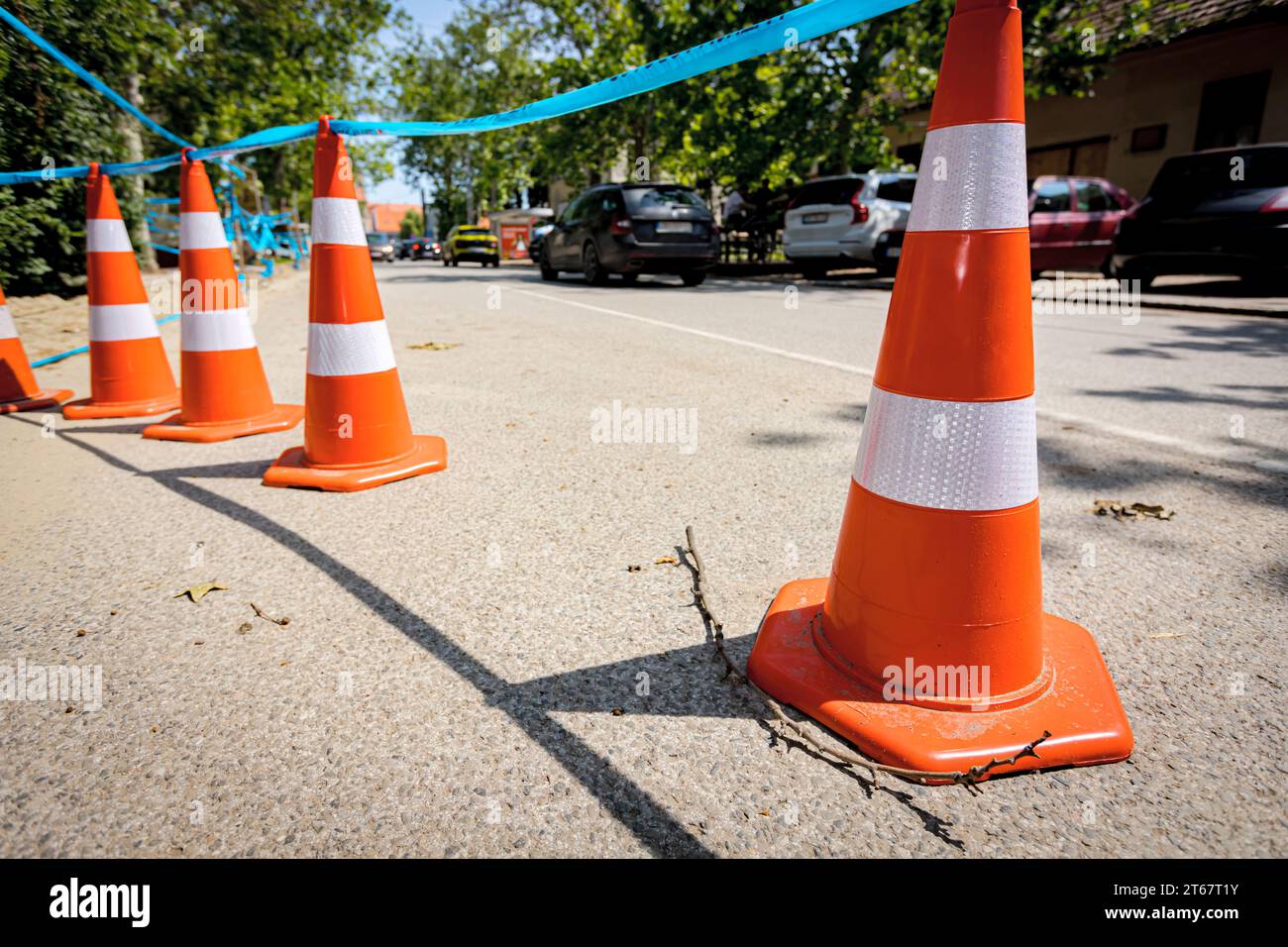 Several orange traffic cones with white fluorescent stripes are on the ...