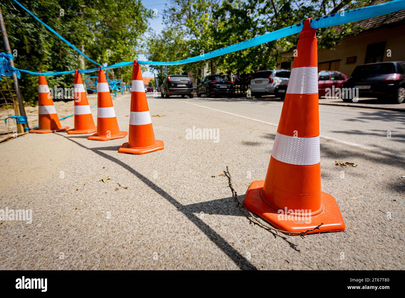 Several orange traffic cones with white fluorescent stripes are on the ...