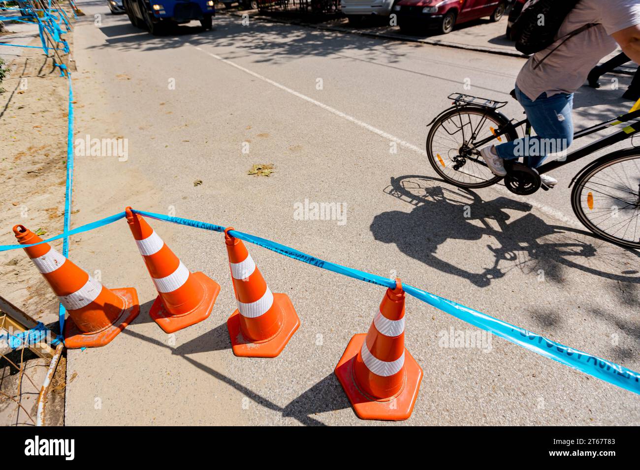 Several orange traffic cones with white fluorescent stripes are on the ...