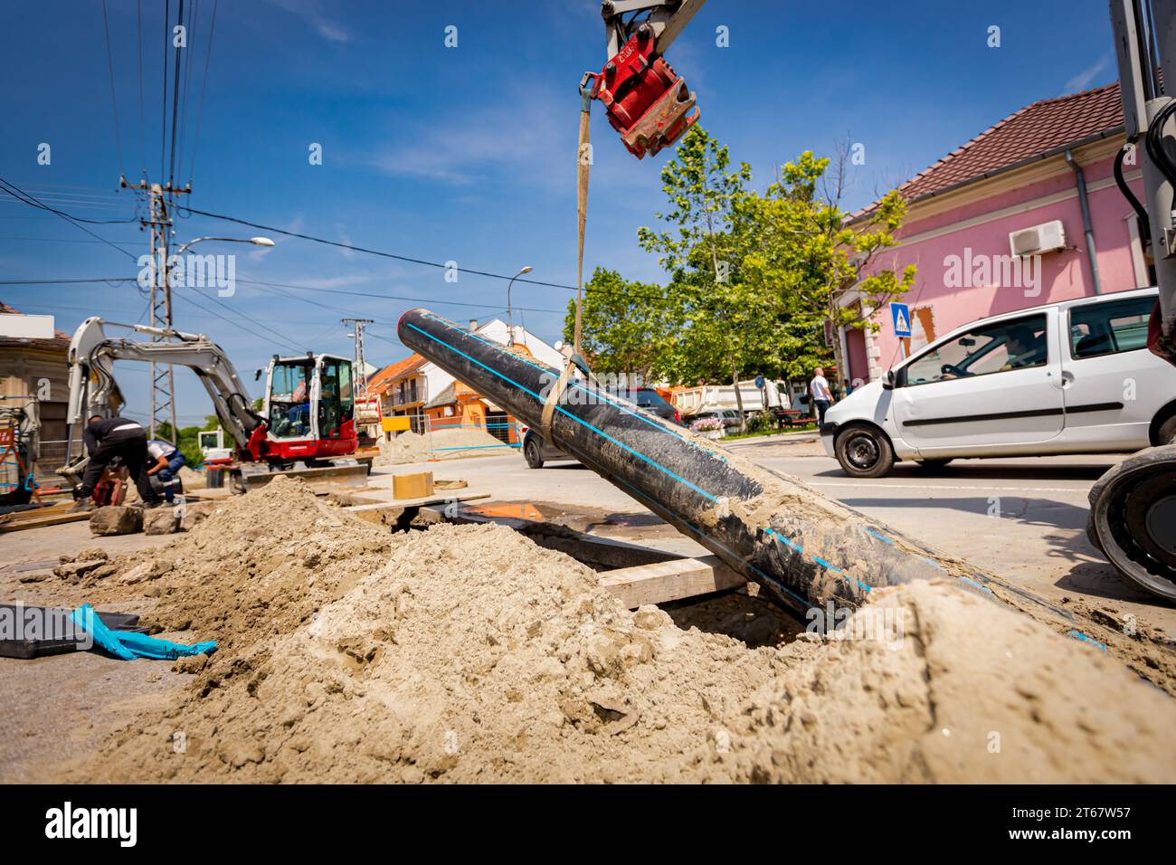 Small excavator with rubber crawler is standing next to the trench with ...