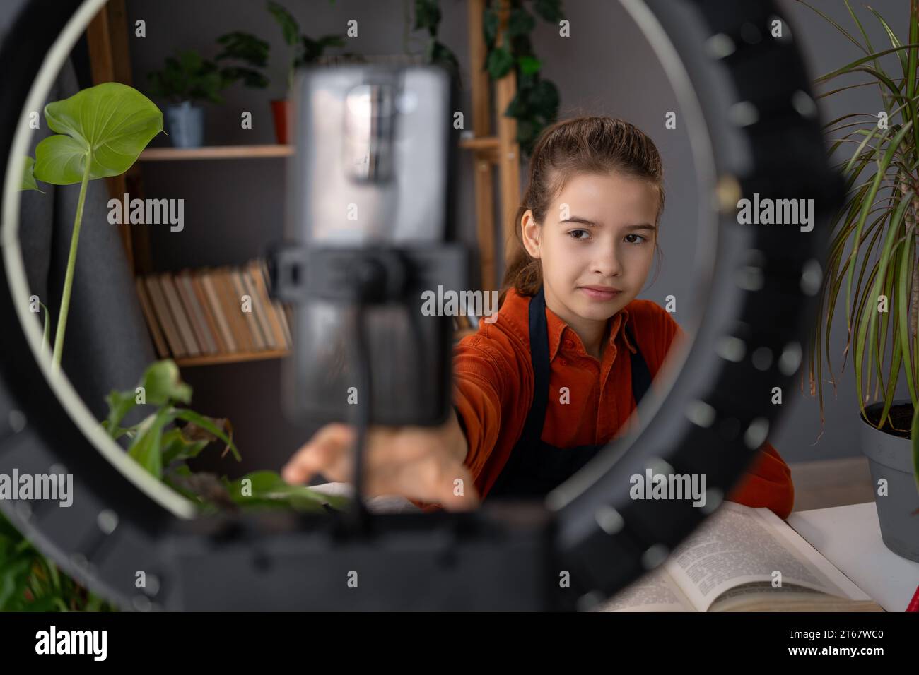 Child recording vlogging online about houseplants and transplant ...