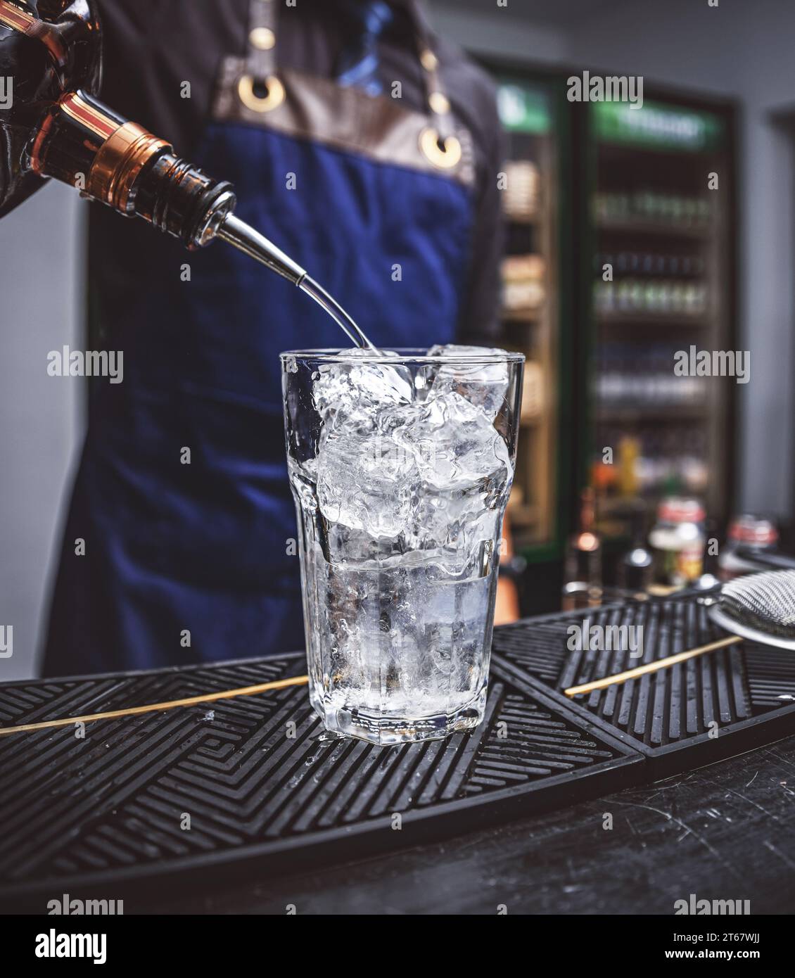 Professional bartender prepare a fresh cocktail in the glass with an ice at the barstand Stock ...
