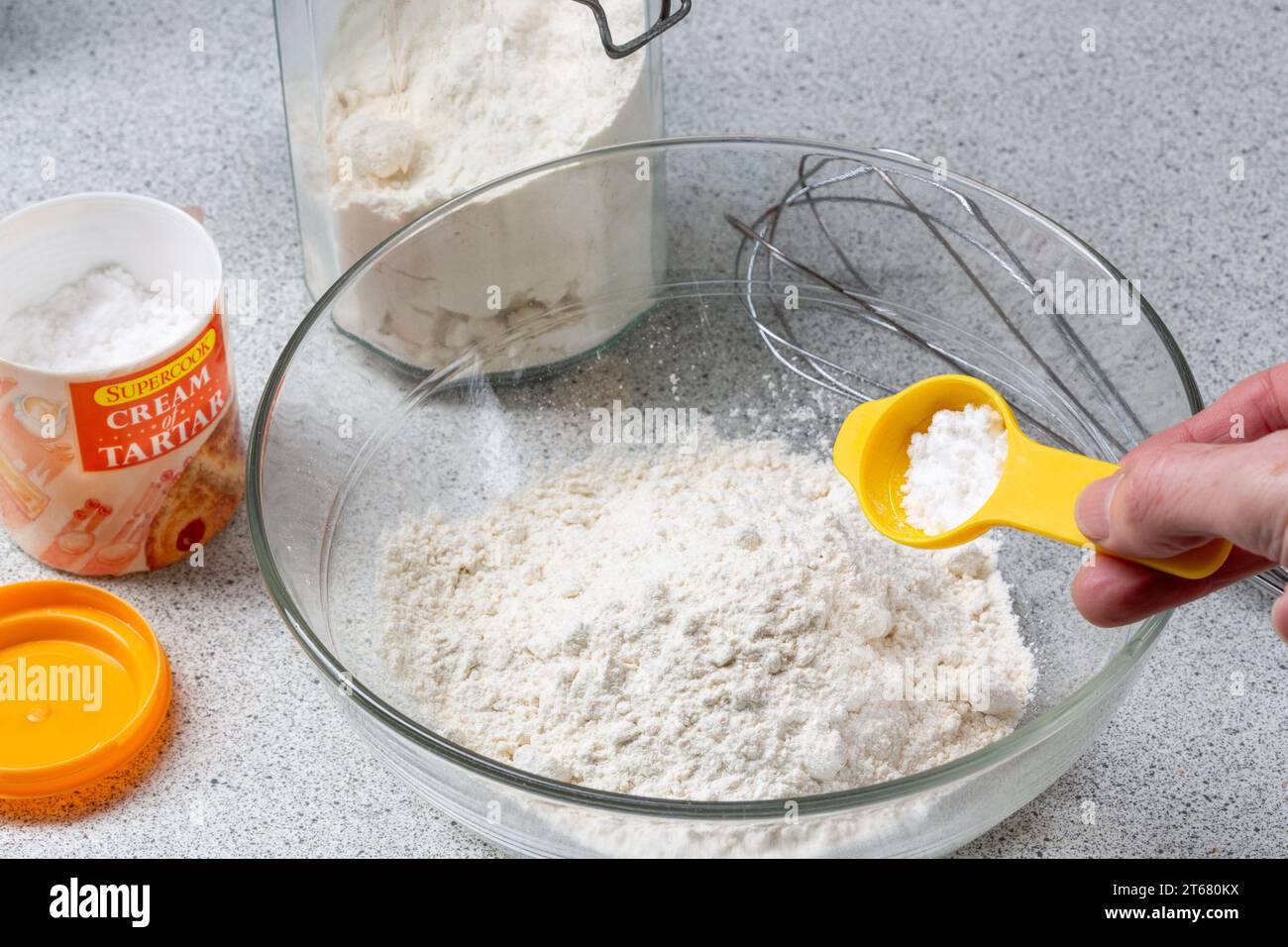 Preparing to add Cream of tartar to flour in a glass mixing bowl Stock ...