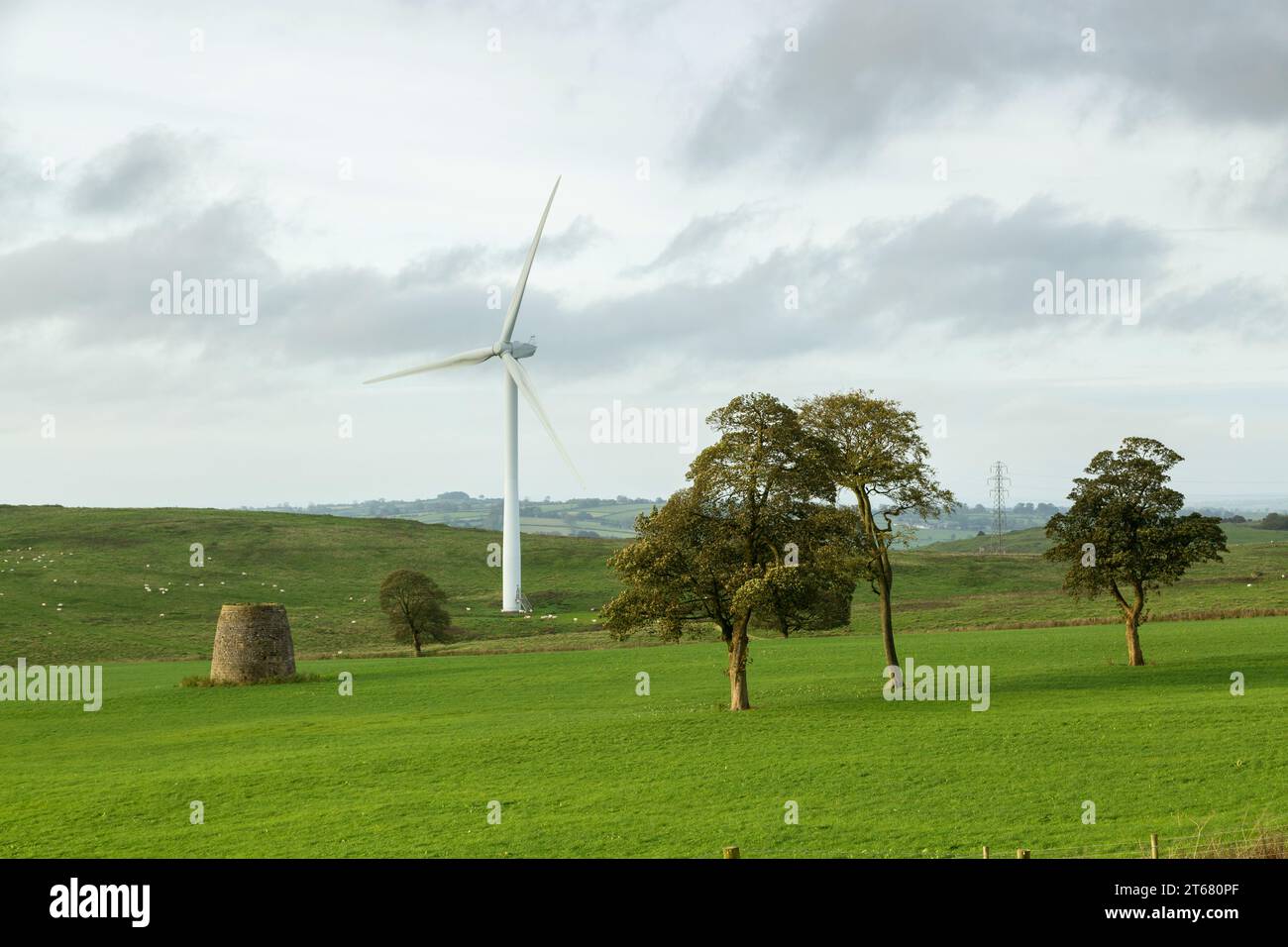 A modern wind farm and an old stone windmill seen from the High Peak ...