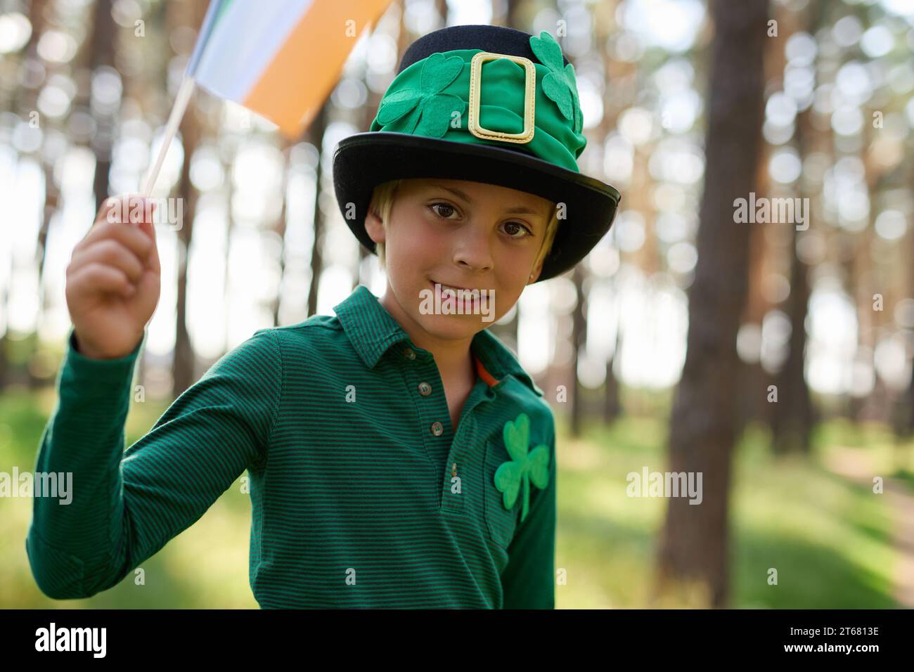 Cute little boy in a leprechaun costume waving with national Irish flag ...