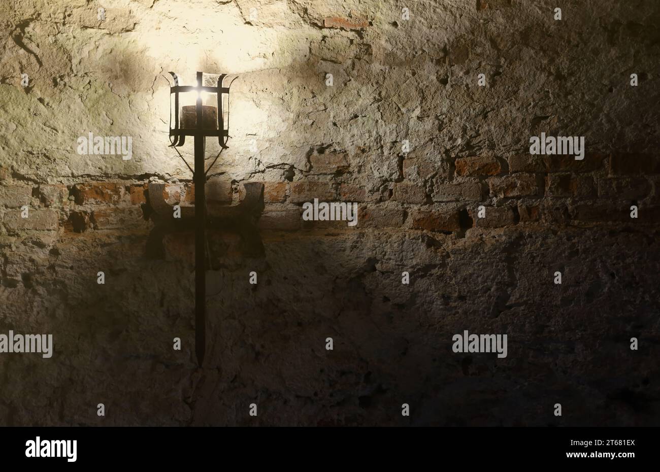 Lighted medieval castle torch hanging on a stone wall, vintage objects ...