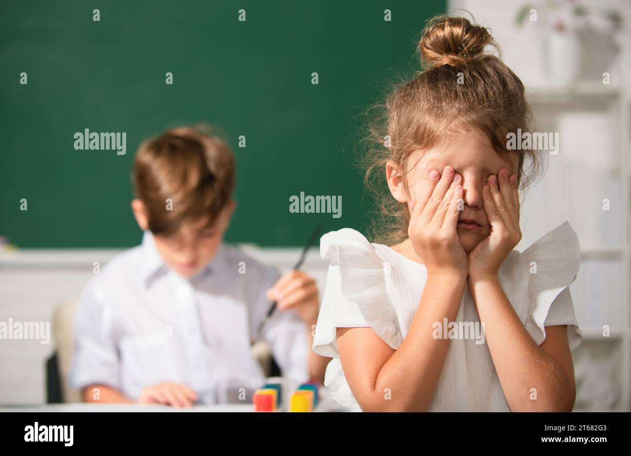 A smart school girl cry. Schoolgirl in uniform covering her face with ...