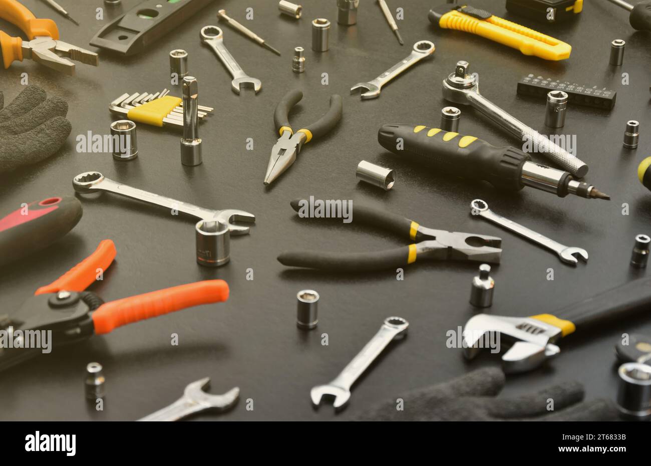 Handyman tool kit on black wooden table. Many wrenches and screwdrivers ...