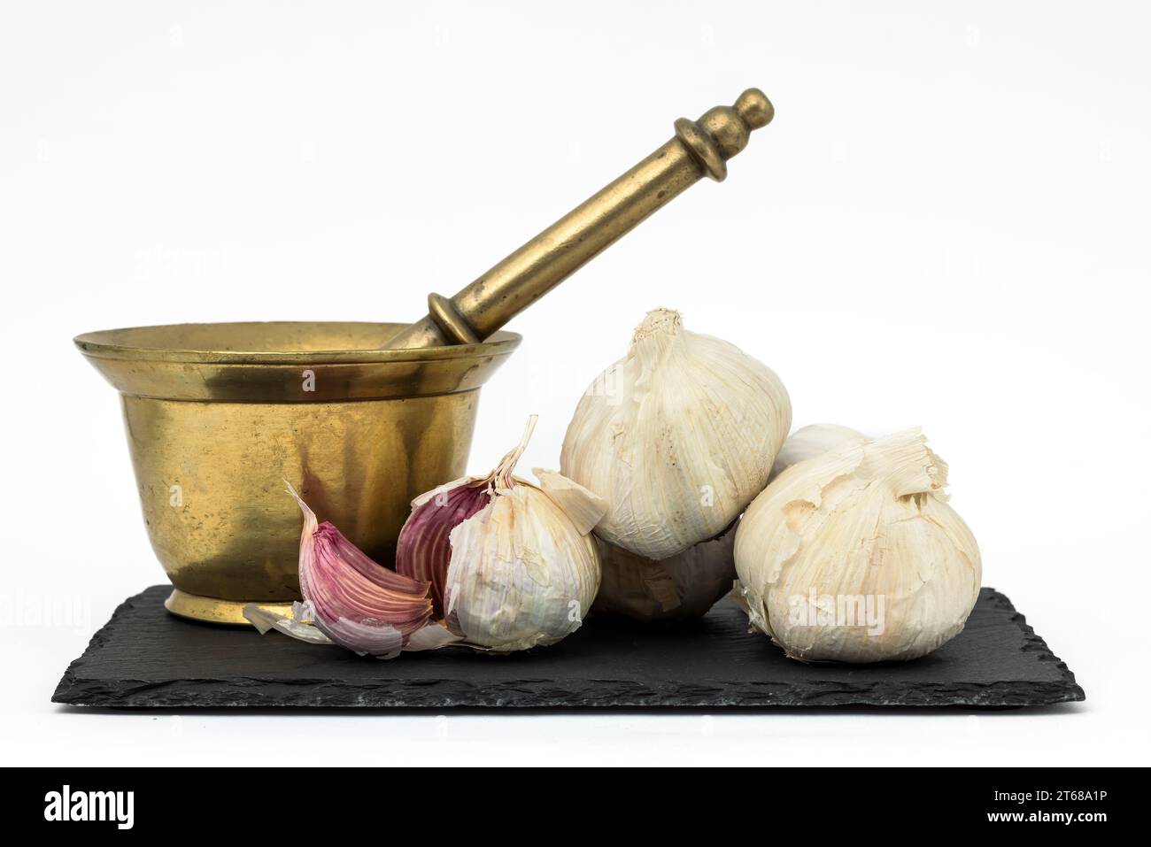 A bundle of fresh garlic cloves in a pile, lying on top of a blackboard ...
