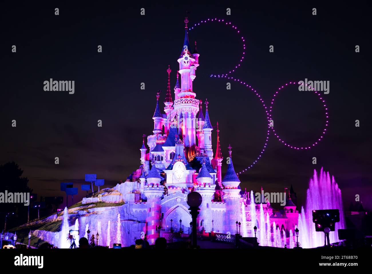 A stunning night shot of the iconic Disneyland castle lit up with ...