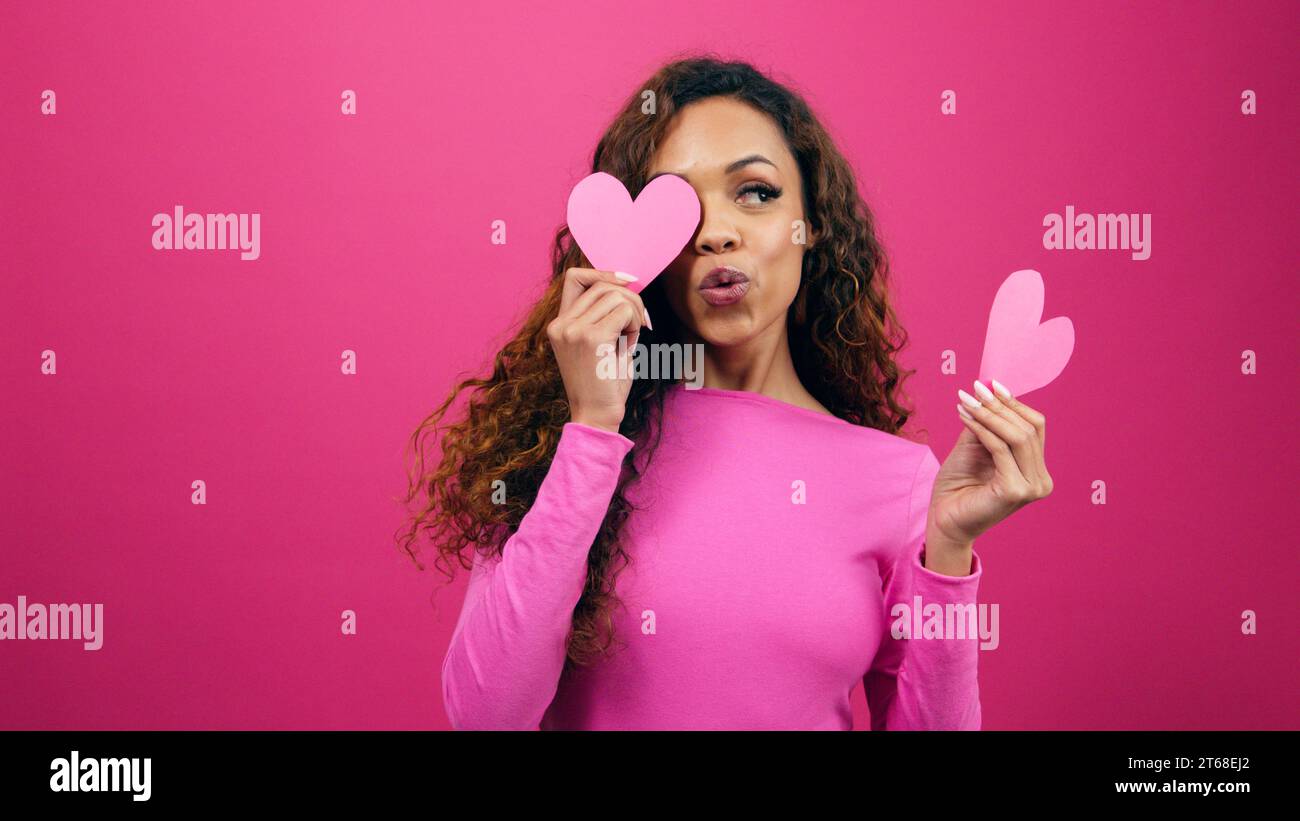 Cute multi-ethnic woman poses with paper hearts, symbol of love studio ...