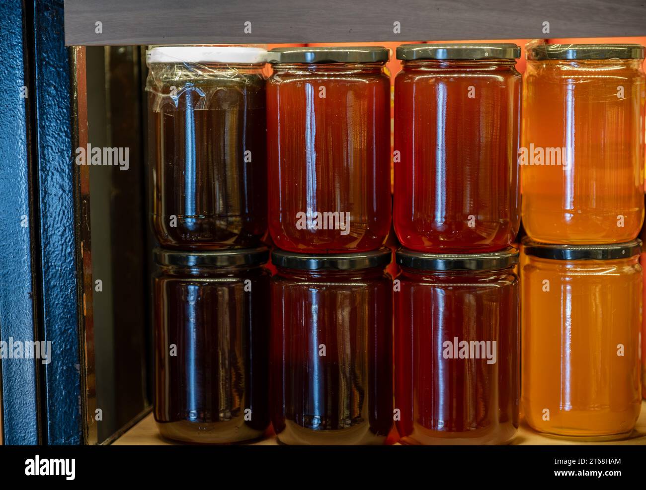 Honey store counter top full of types of honey jars in different colors ...